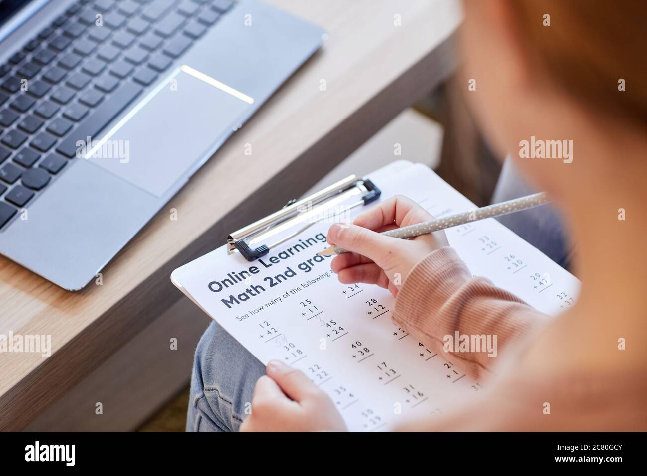 High angle close up of unrecognizable kid doing math test for online ...