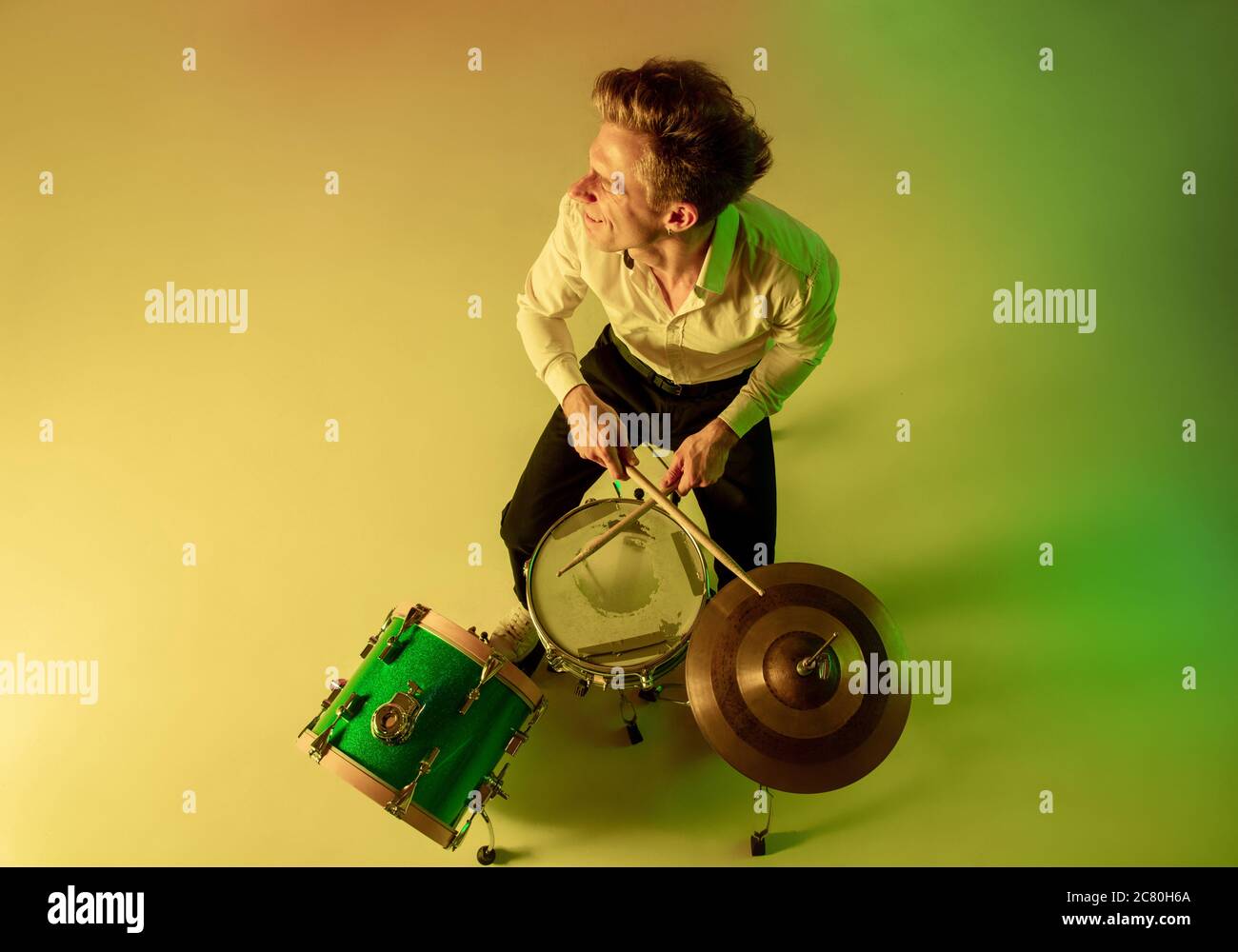 Top view. Young caucasian inspired and expressive musician, drummer ...