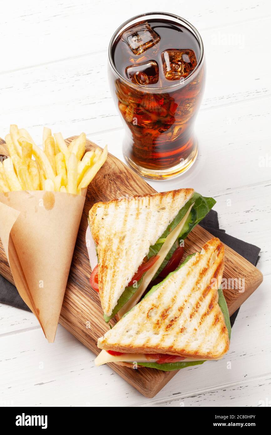 Club sandwich, potato fries chips and glass of cola drink with ice ...