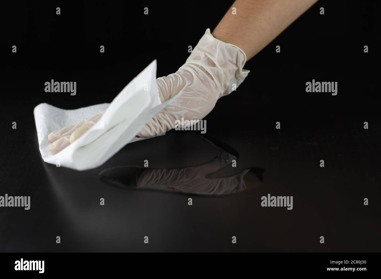 Closeup shot of a hand wearing a glove wiping a liquid spill on the ...