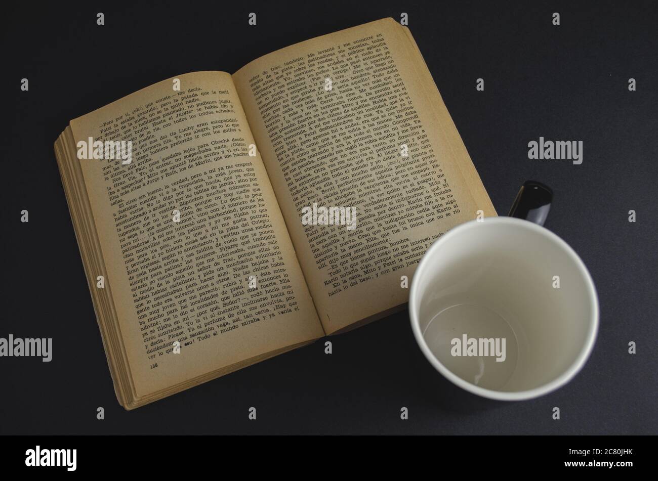 High angle shot of an empty cup with an open book background Stock ...