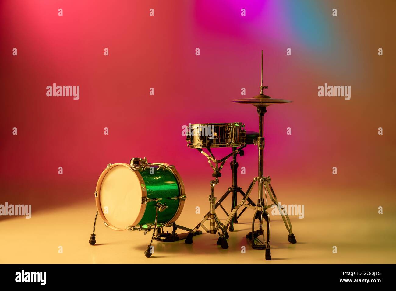 Drum kit or set isolated on multicolored background in neon light ...