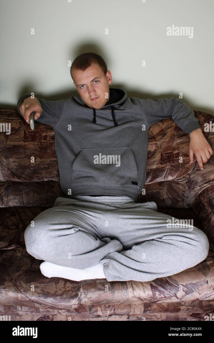 young bored man watching tv Stock Photo - Alamy