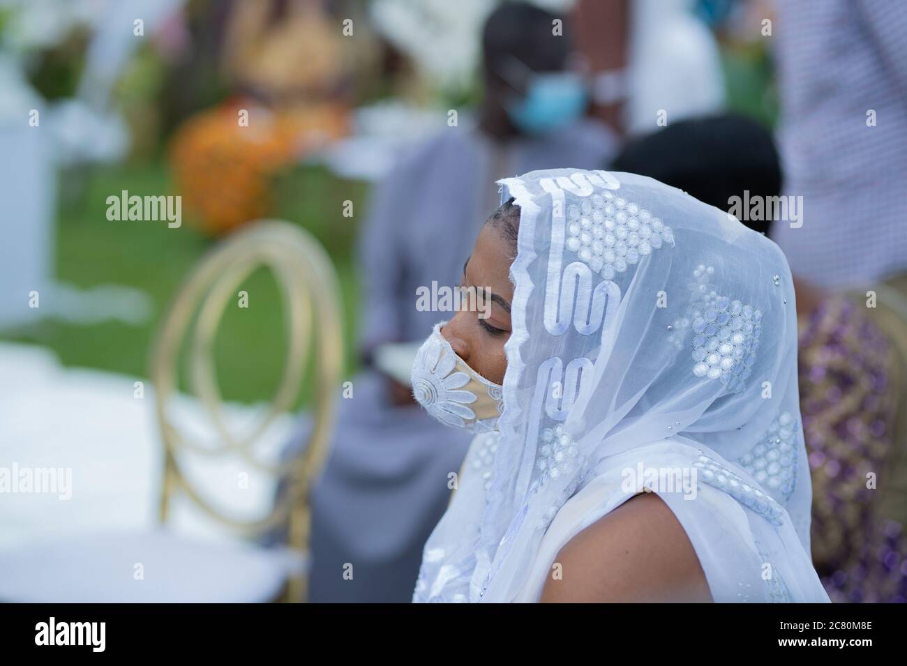 A wedding ceremony held with social distancing and people wearing mask ...
