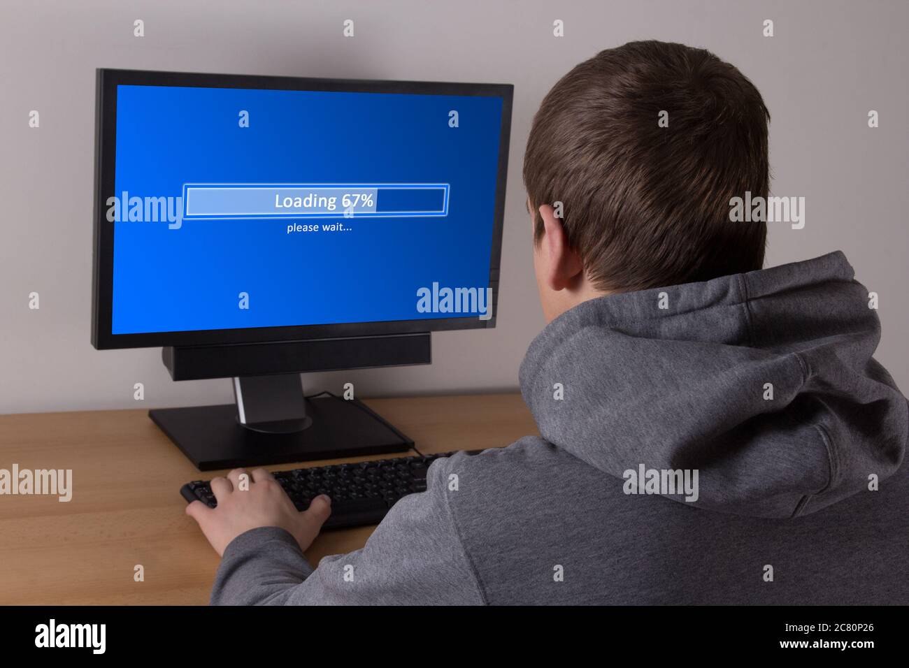 back view of young man using personal computer loading at home Stock ...