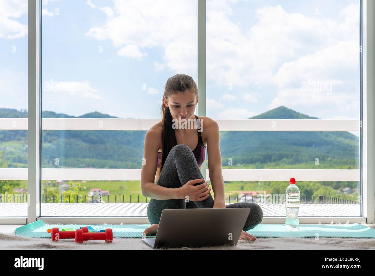 Fitness workout at home watching videos online working on laptop ...