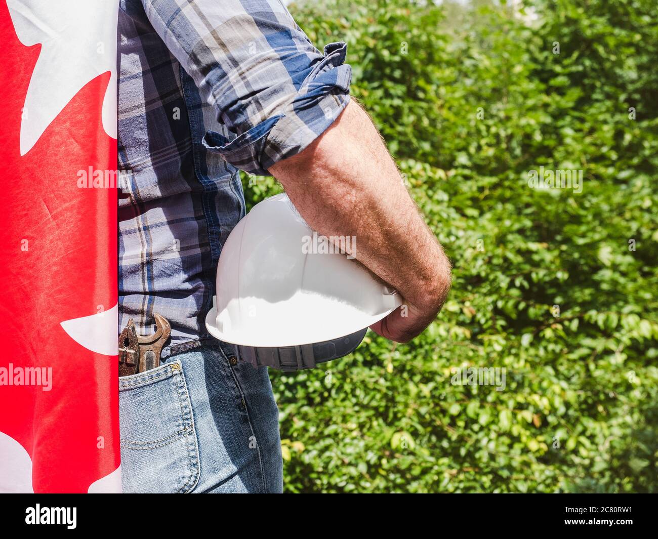 Handsome man with tools, holding a Canadian Flag Stock Photo - Alamy