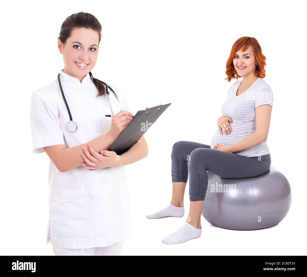 young female doctor with pregnant woman sitting on fitness ball ...