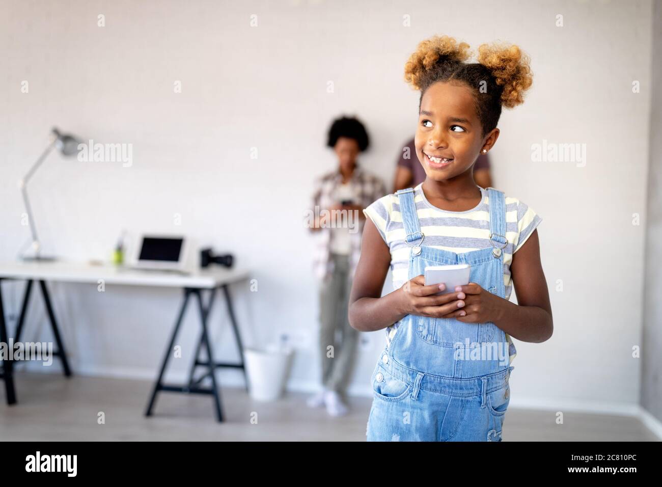 Smiling little girl playing with smartphone. Children, technology ...