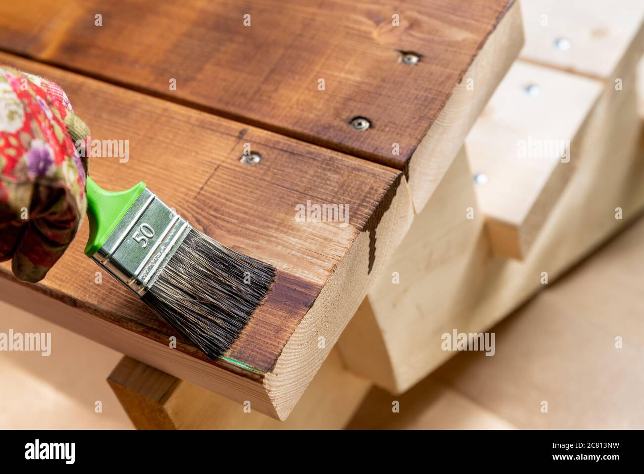 hand holding a brush applying varnish paint on a wooden surface.Home ...