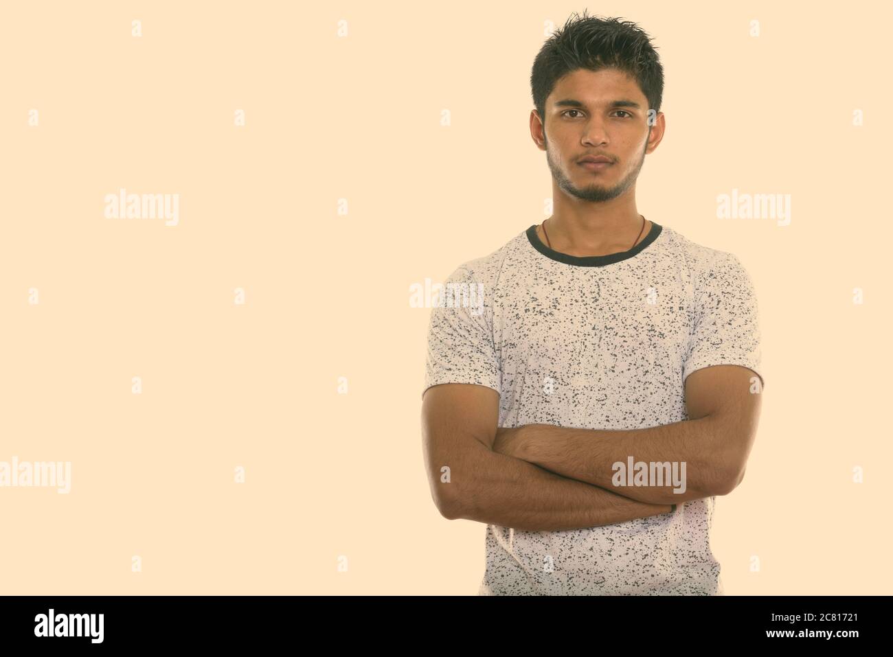 Studio shot of young handsome Indian man with arms crossed Stock Photo ...