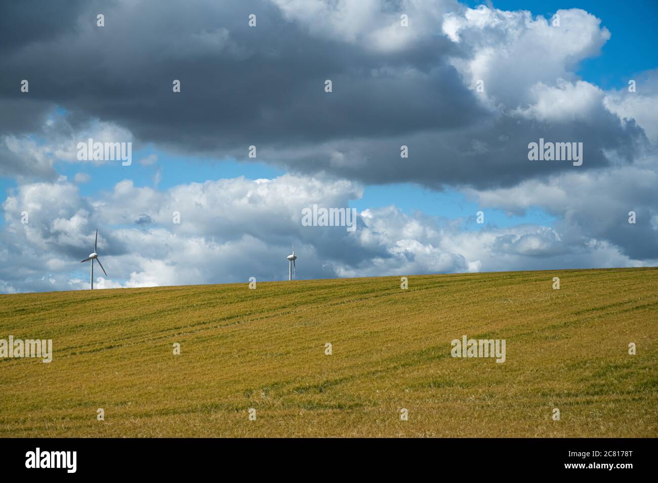 Windmill turbines in the valley under the cloudy sky Stock Photo - Alamy