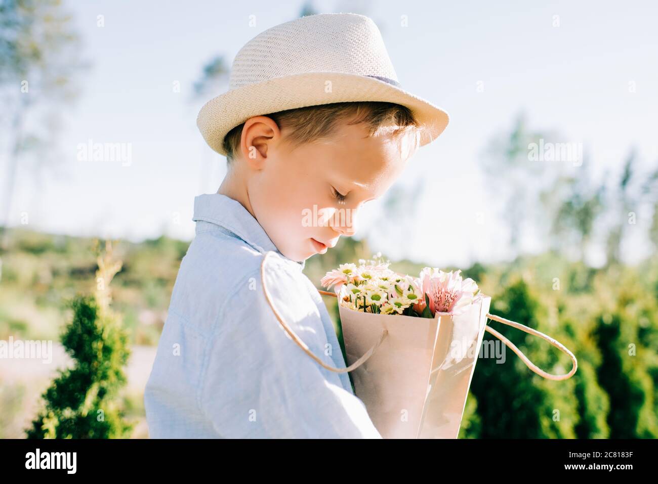 handsome young boy looking at a beautiful bouquet of flowers Stock ...