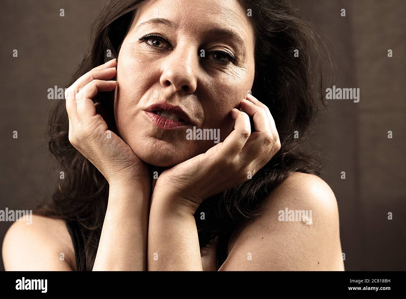 portrait of mature woman with hands near face Stock Photo - Alamy
