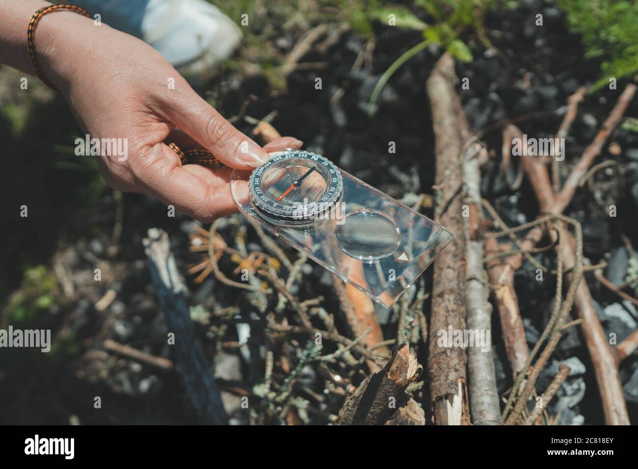 Woman uses a magnifying glass to burn a bonfire Stock Photo - Alamy