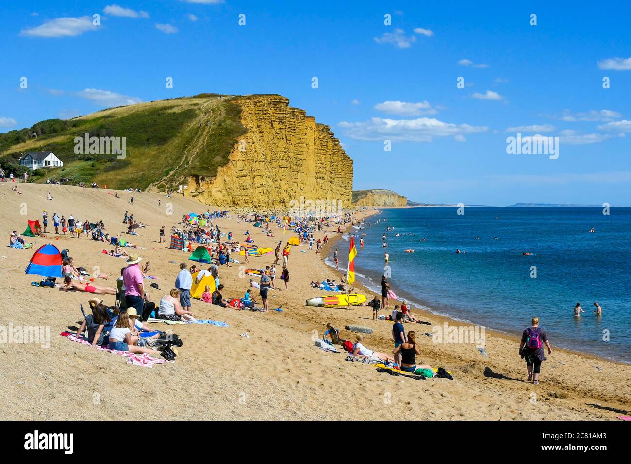 West Bay, Dorset, UK. 20th July 2020. UK Weather. Sunbathers and ...