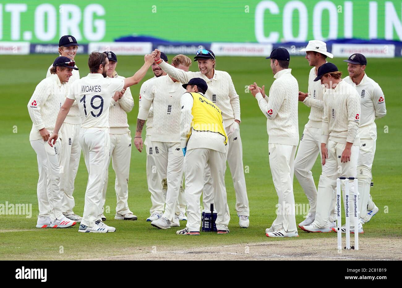 England's Chris Woakes celebrates with his team-mates after taking the ...