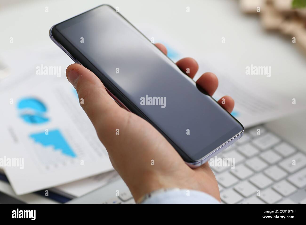 Executive using gadgets while working with documents Stock Photo - Alamy