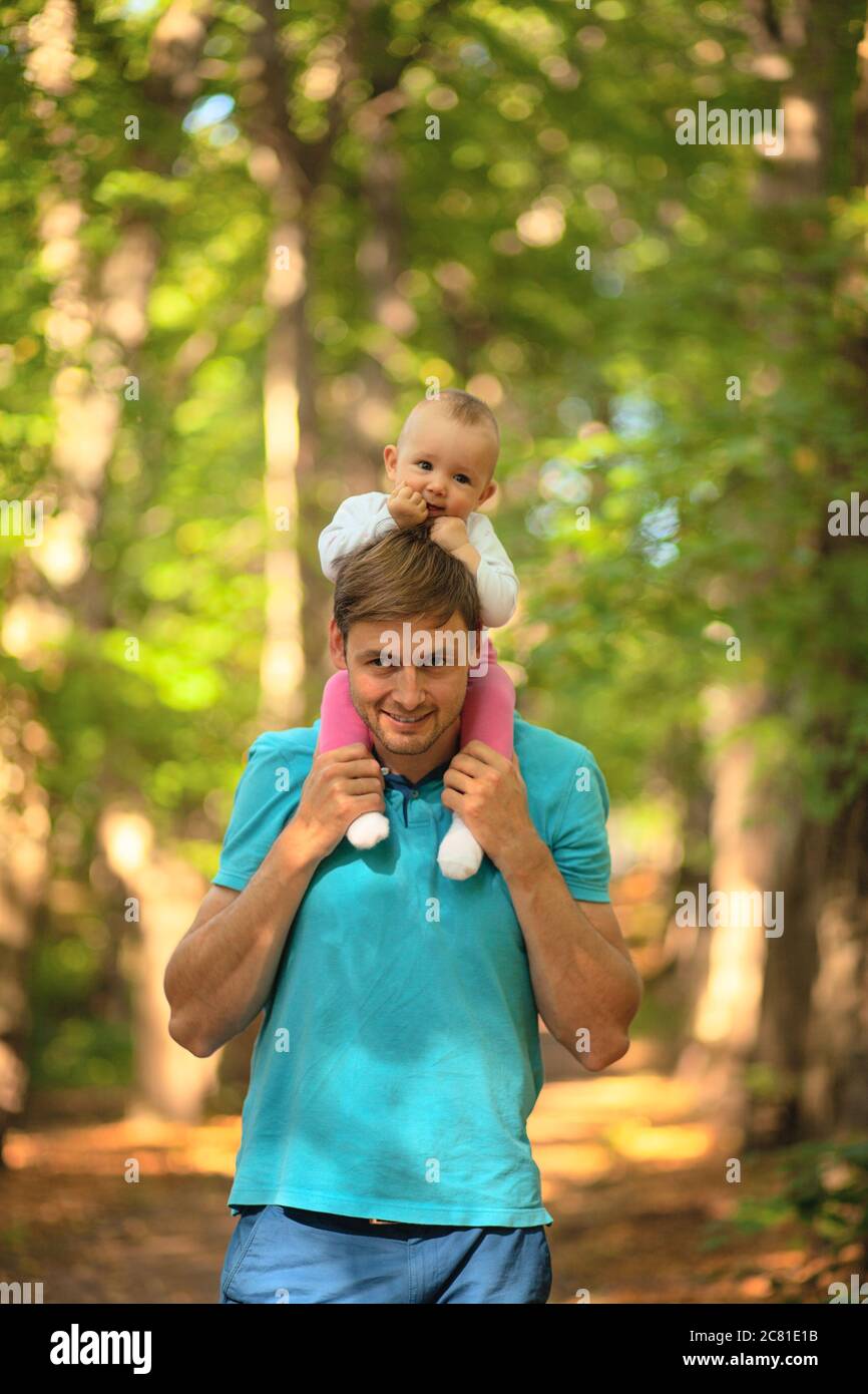 The child sits on his fathers shoulders. Father and baby walking in the ...