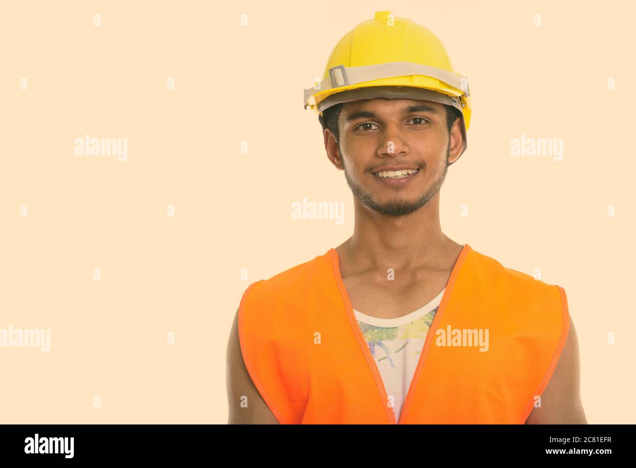 Studio shot of young happy Indian man construction worker smiling Stock ...