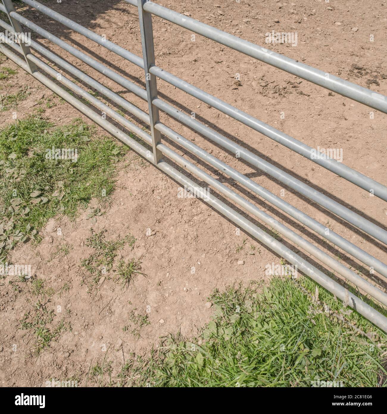 Galvanized metal farm gate in baking summer weather. Part of a cattle ...