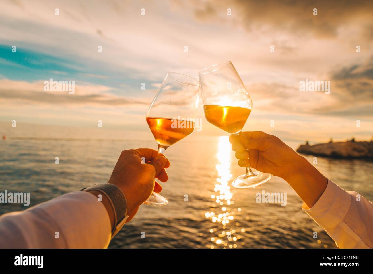 couple resting on sunset at sea beach and drinking wine Stock Photo - Alamy