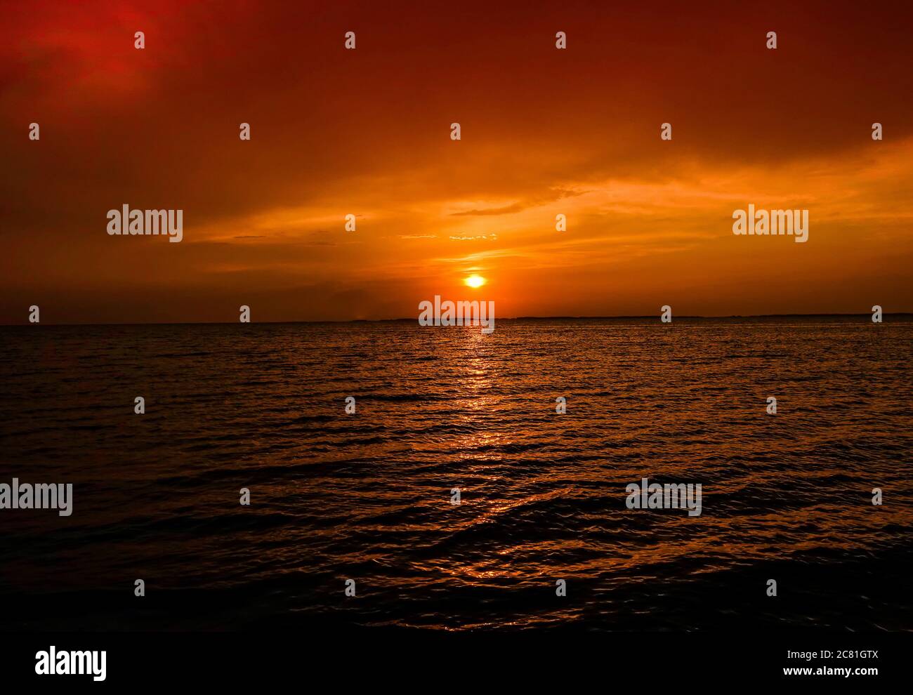 Setting sun caught in a gap in the clouds Stock Photo - Alamy