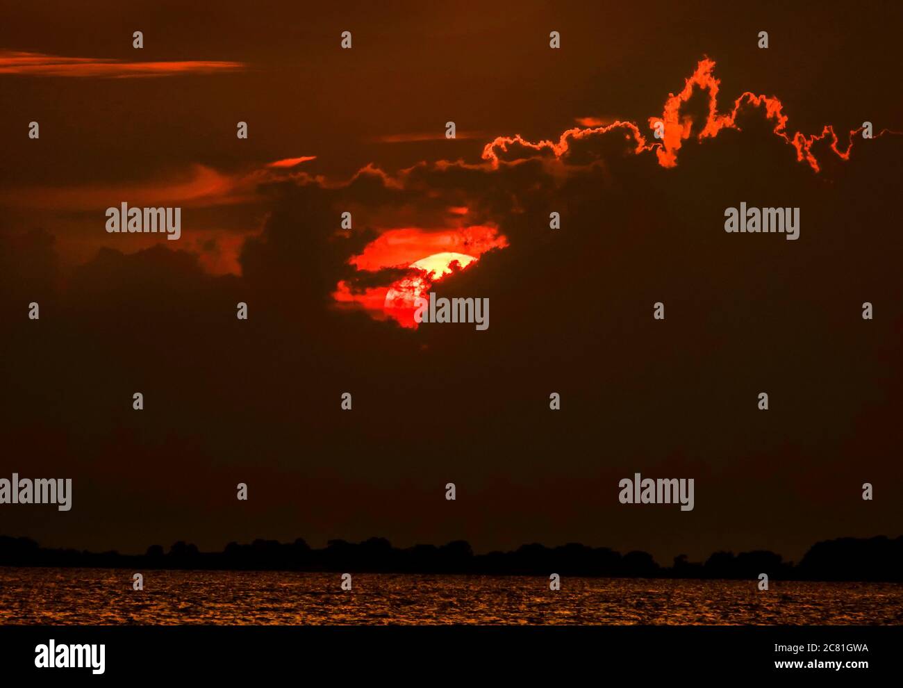 Setting sun caught in a gap in the clouds Stock Photo - Alamy