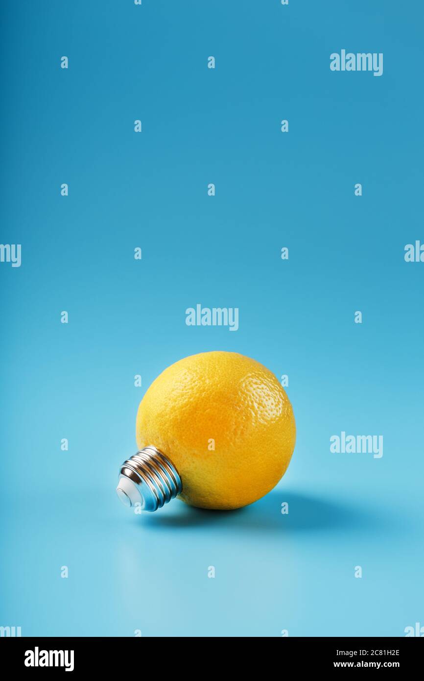 Lemon fruit as a light bulb on a blue background. The conceptual idea ...