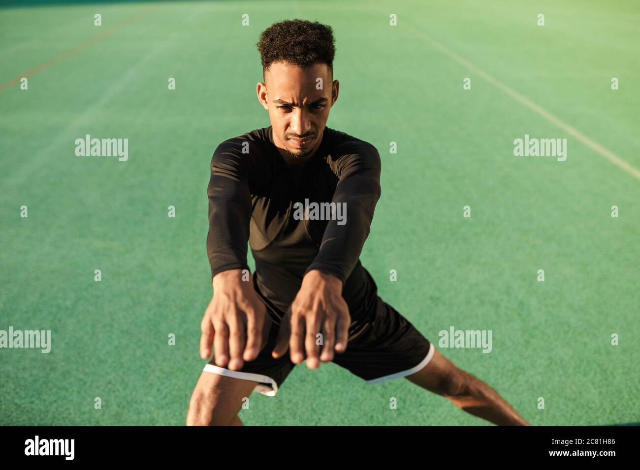 Young angry African American sportsman doing exercises during hard ...