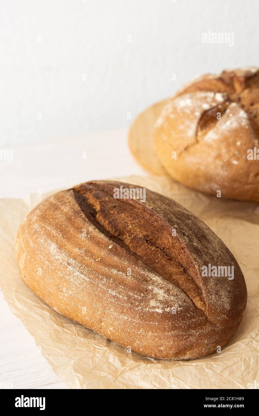 Loaf of homemade bread from wheat and seeds on parchment paper Stock ...