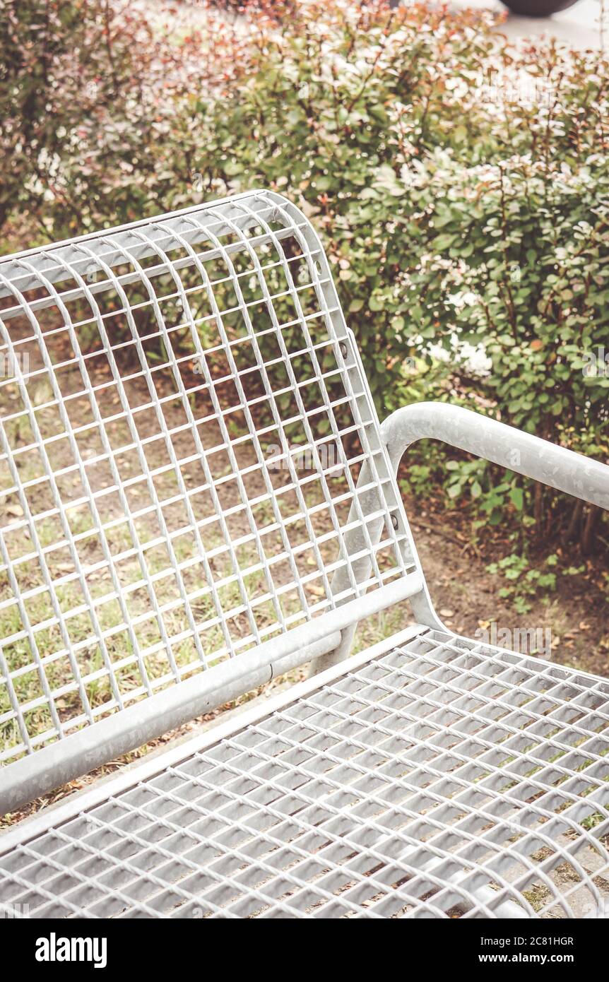 Vertical shot of a white metal bench in a park during the daytime Stock ...