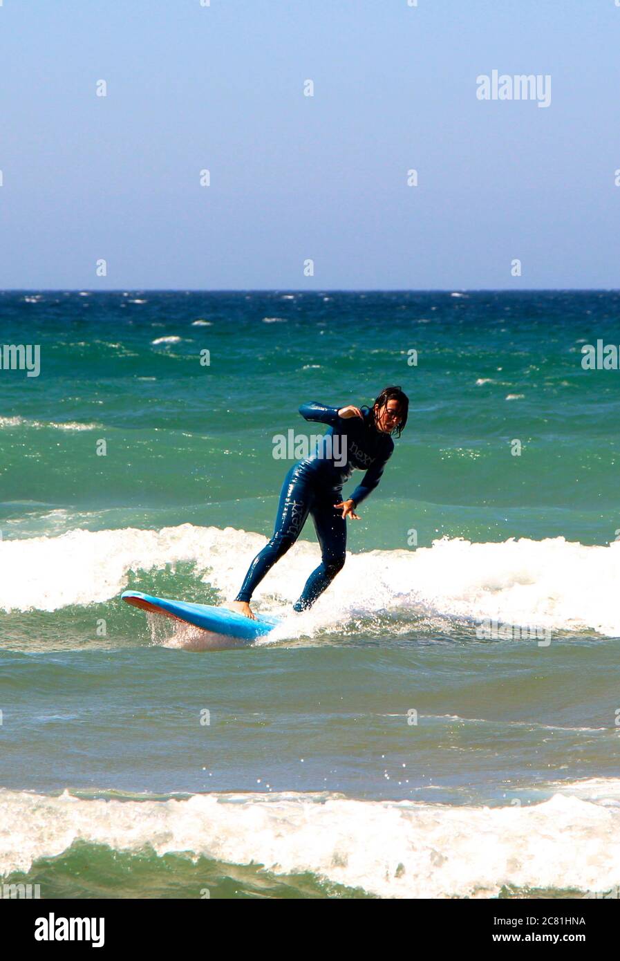 Young woman surfing on a rough windy day Stock Photo - Alamy