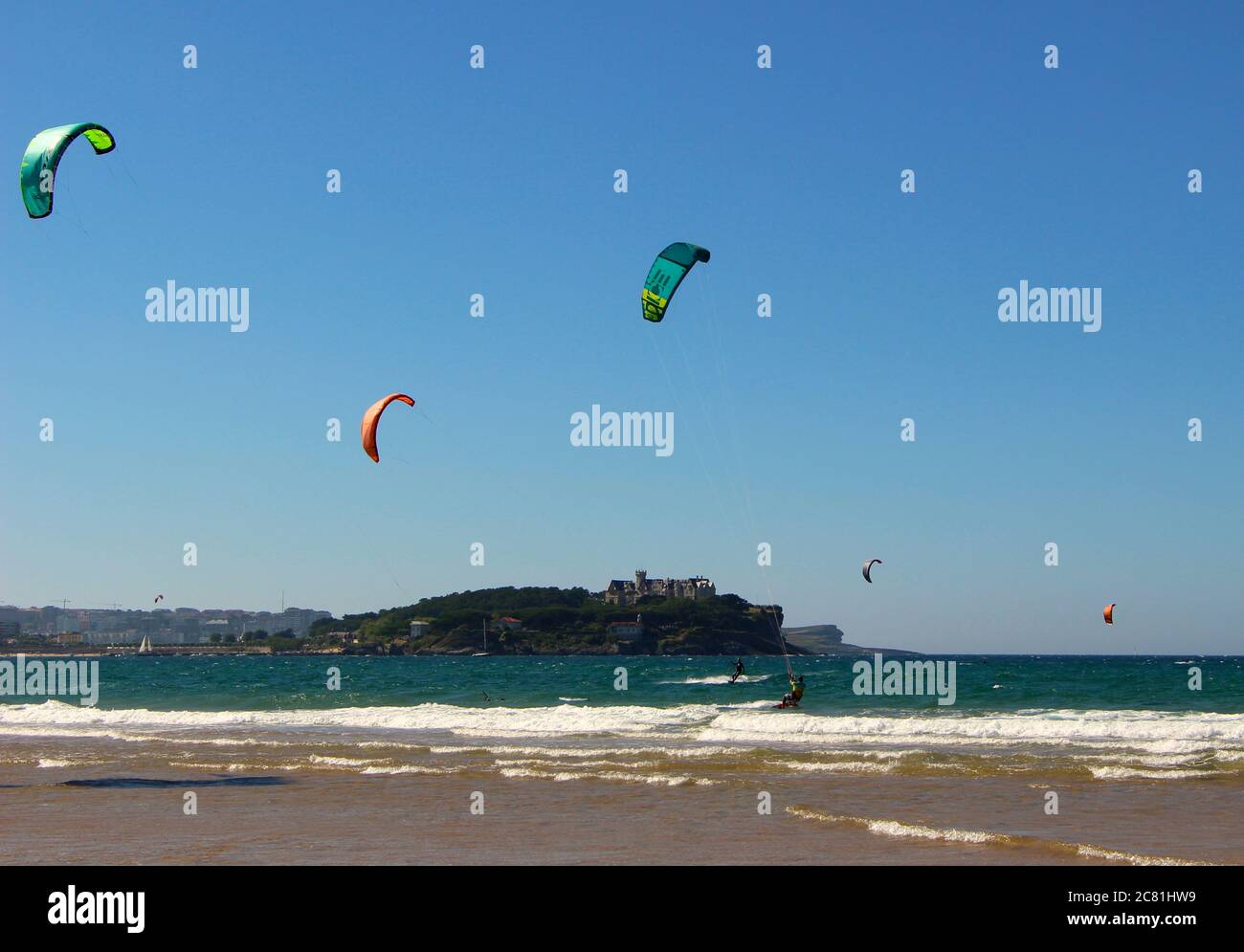 Kitesurfing or kiteboarding from the beach of Somo on a sunny windy ...