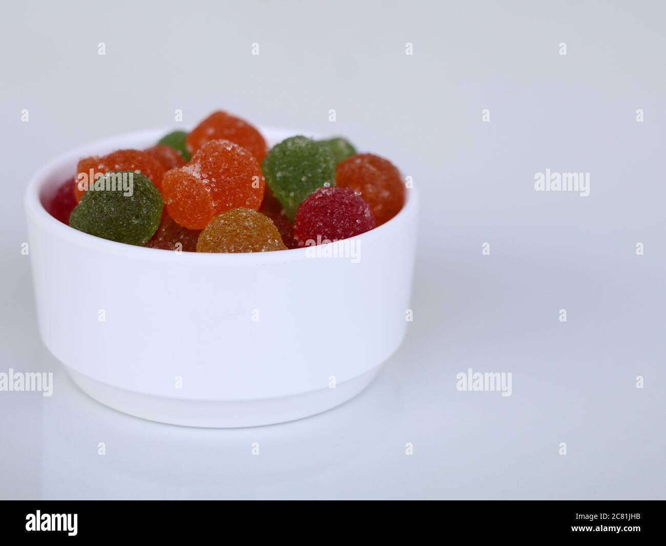 Sweet mixed color jelly candy in a white bowl against white background ...