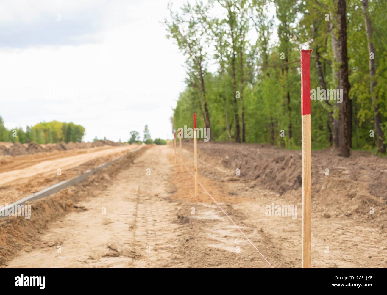 The construction of a wide road and sidewalk. Marking in the sand for a ...
