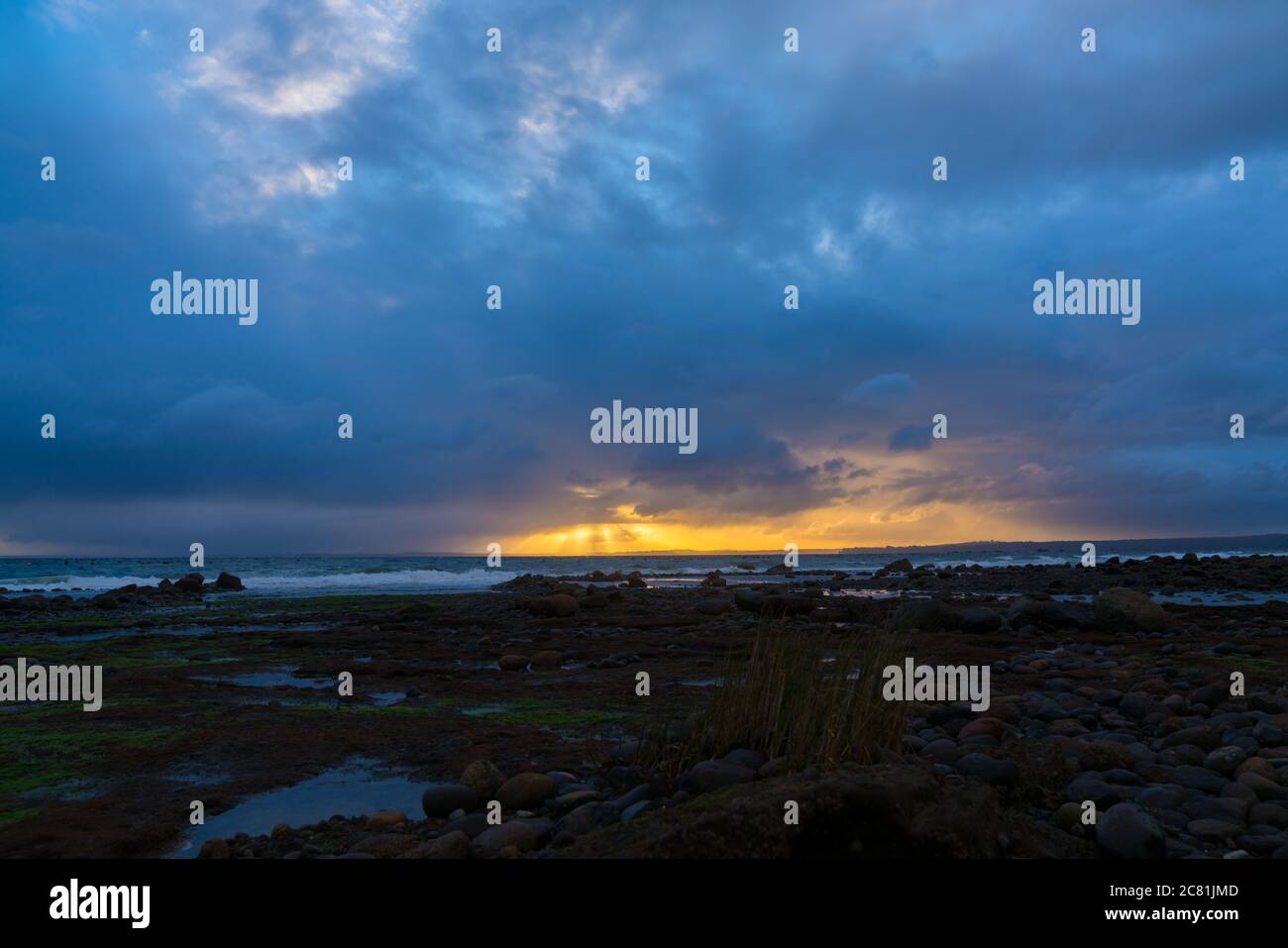 A sunset over the sea, with bad weather and rain Stock Photo - Alamy