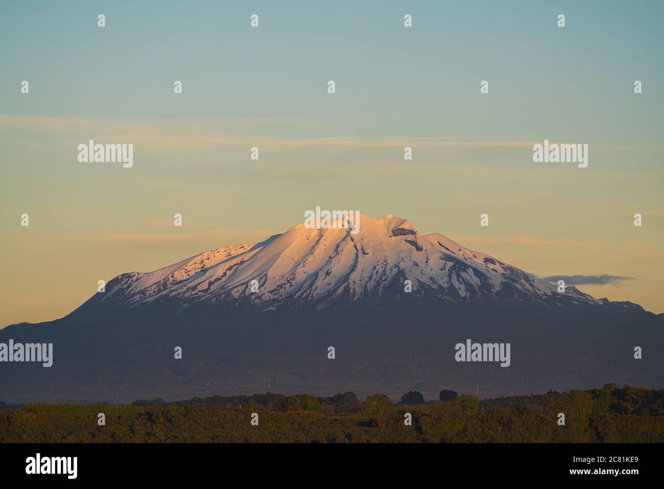 calbuco volcano with golden light on its snowy top and clouds in the ...