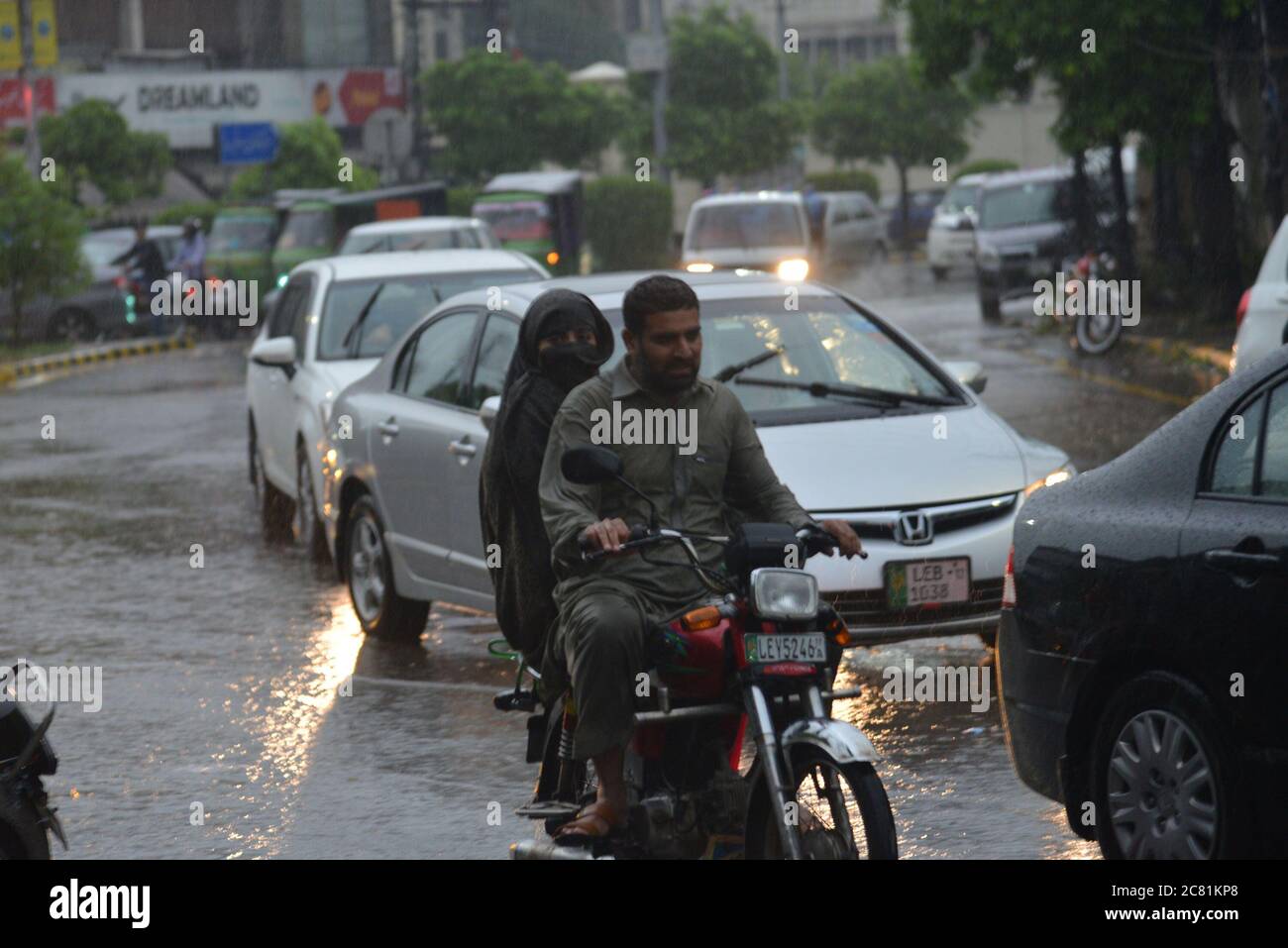 Lahore, Pakistan. 20th July, 2020. Pakistani commuters wade through a ...