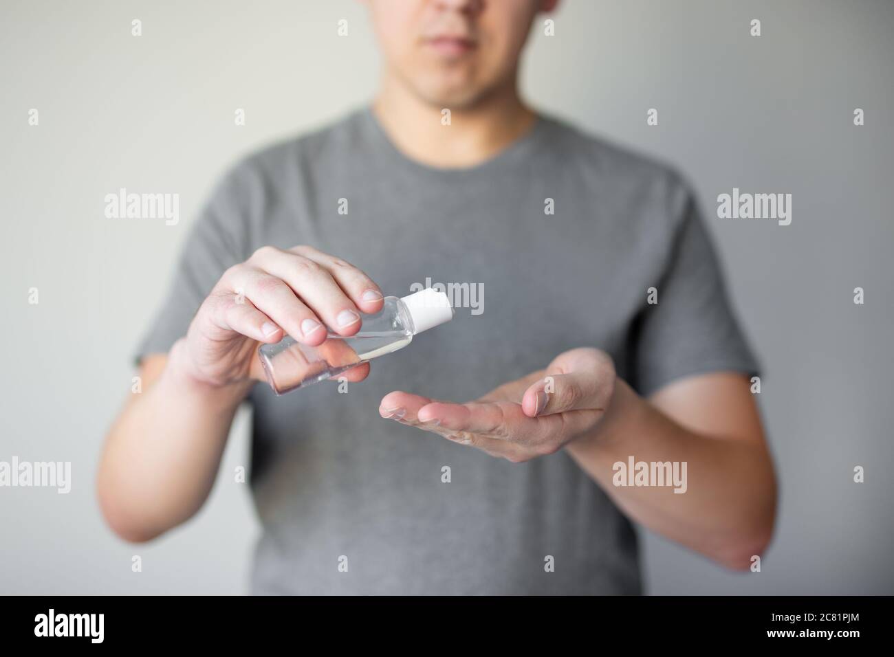 hand hygiene or disinfection concept - young man using sanitizer gel ...