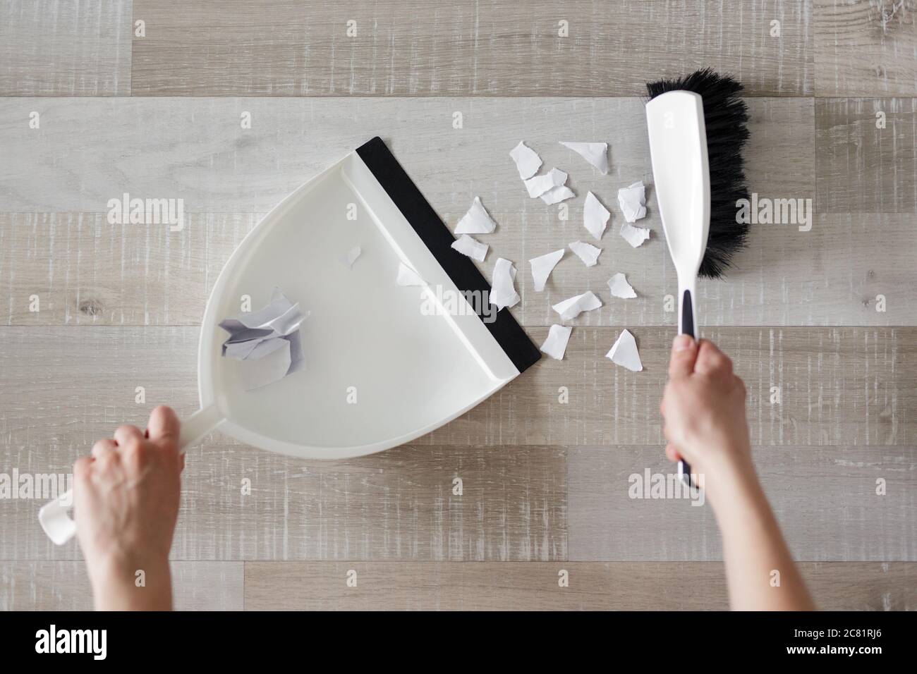 top view of male hands cleaning ripped pieces of paper with scoop and ...