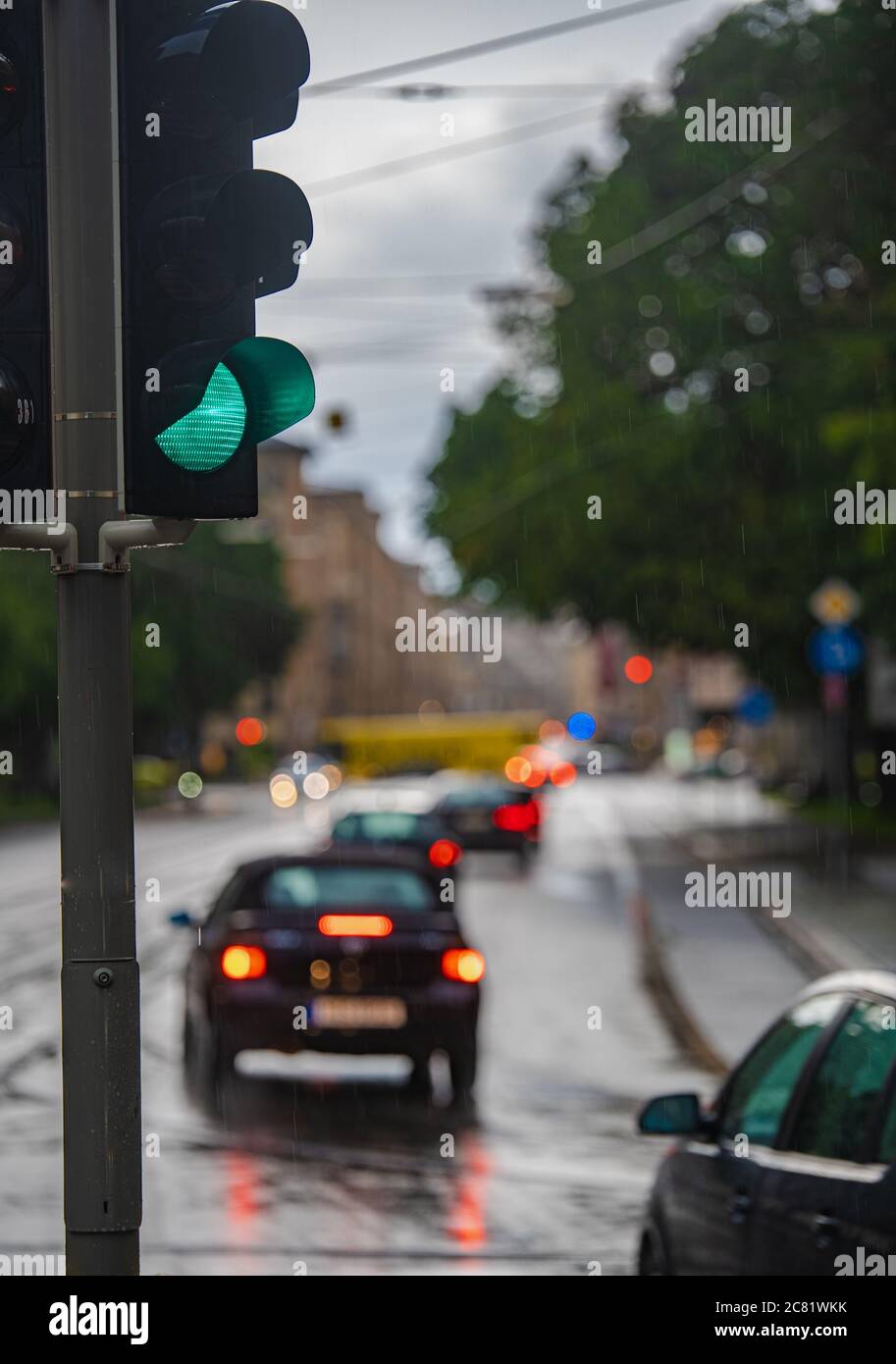 Green traffic light during the rain, Cars drive by Stock Photo - Alamy