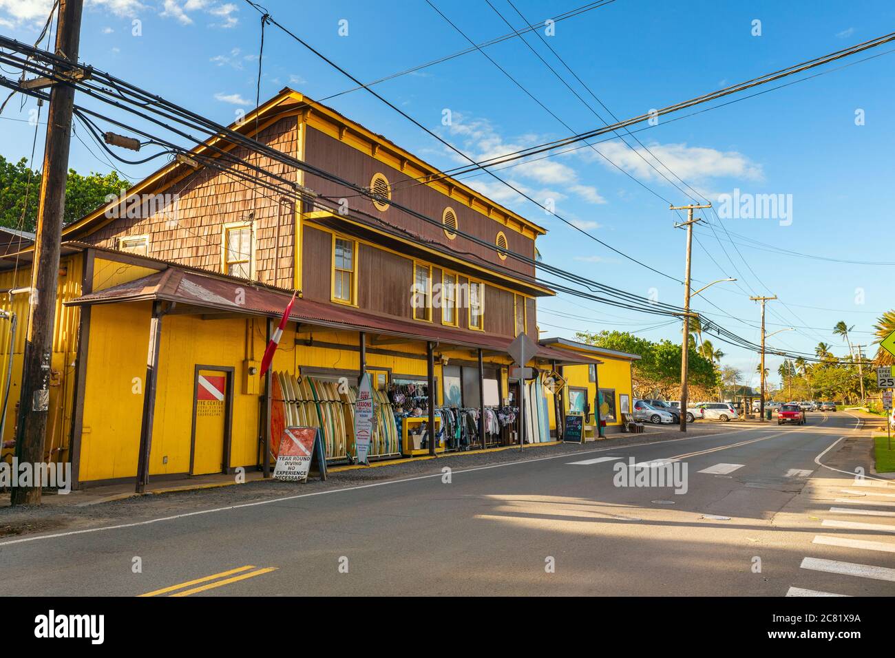 Surf town of Haleiwa, with a bright yellow building renting surfboards ...