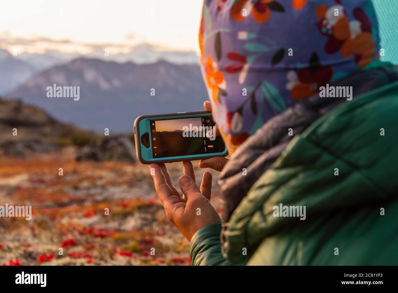 Woman taking photograph of Denali and Alaska Range at sunset from ...