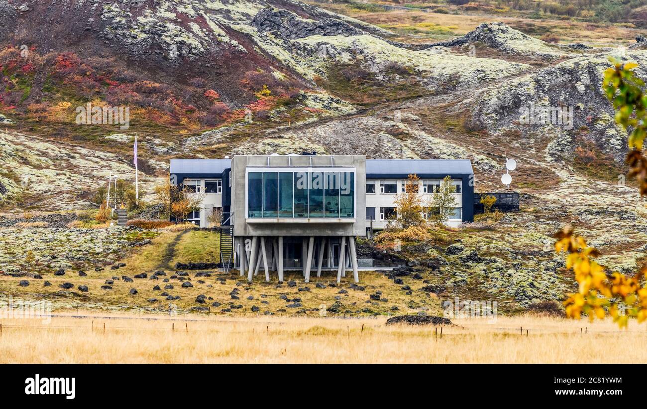 Building with large windows on barren landscape with autumn colours ...