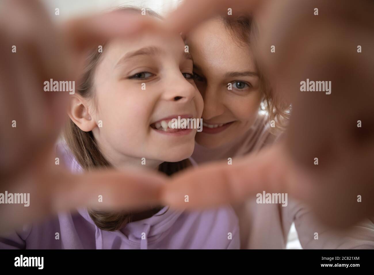 Close up happy mother and teenage daughter making heart gesture Stock ...