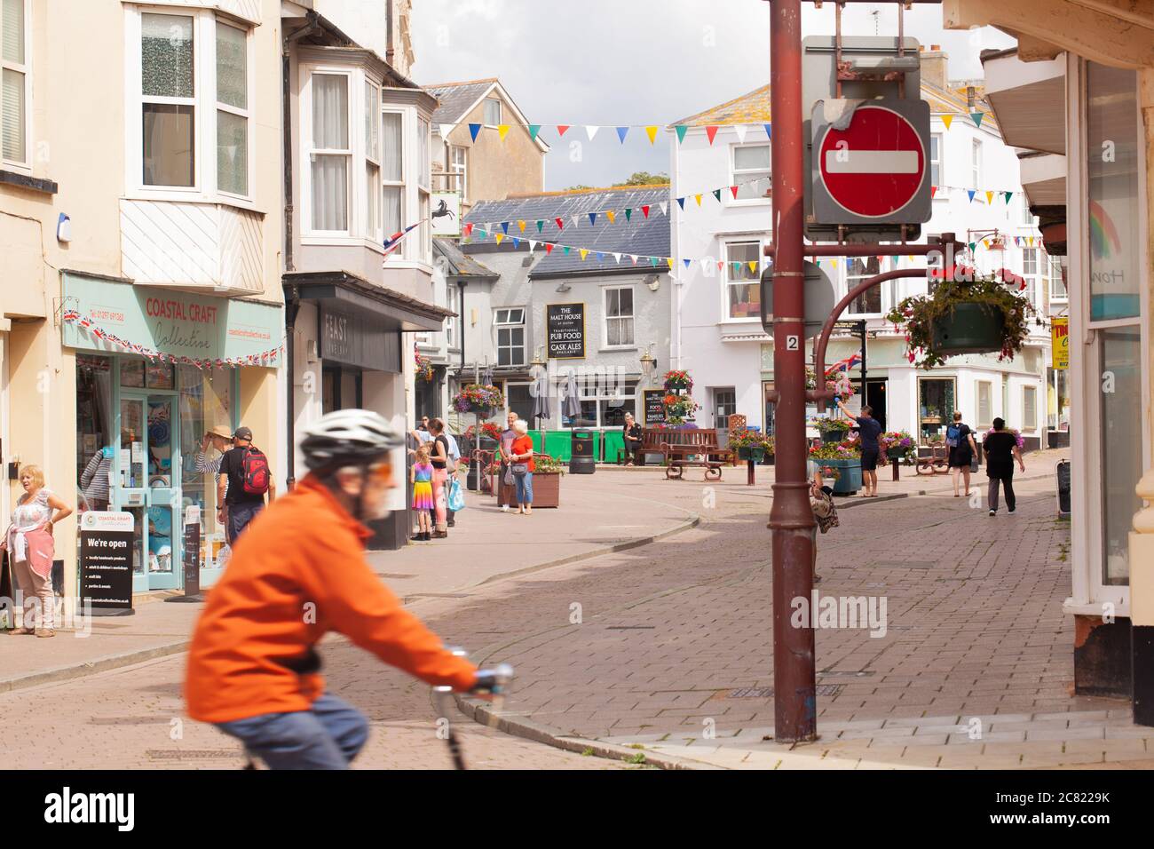 Business/British Economy concept - cyclist rides across high-street as ...