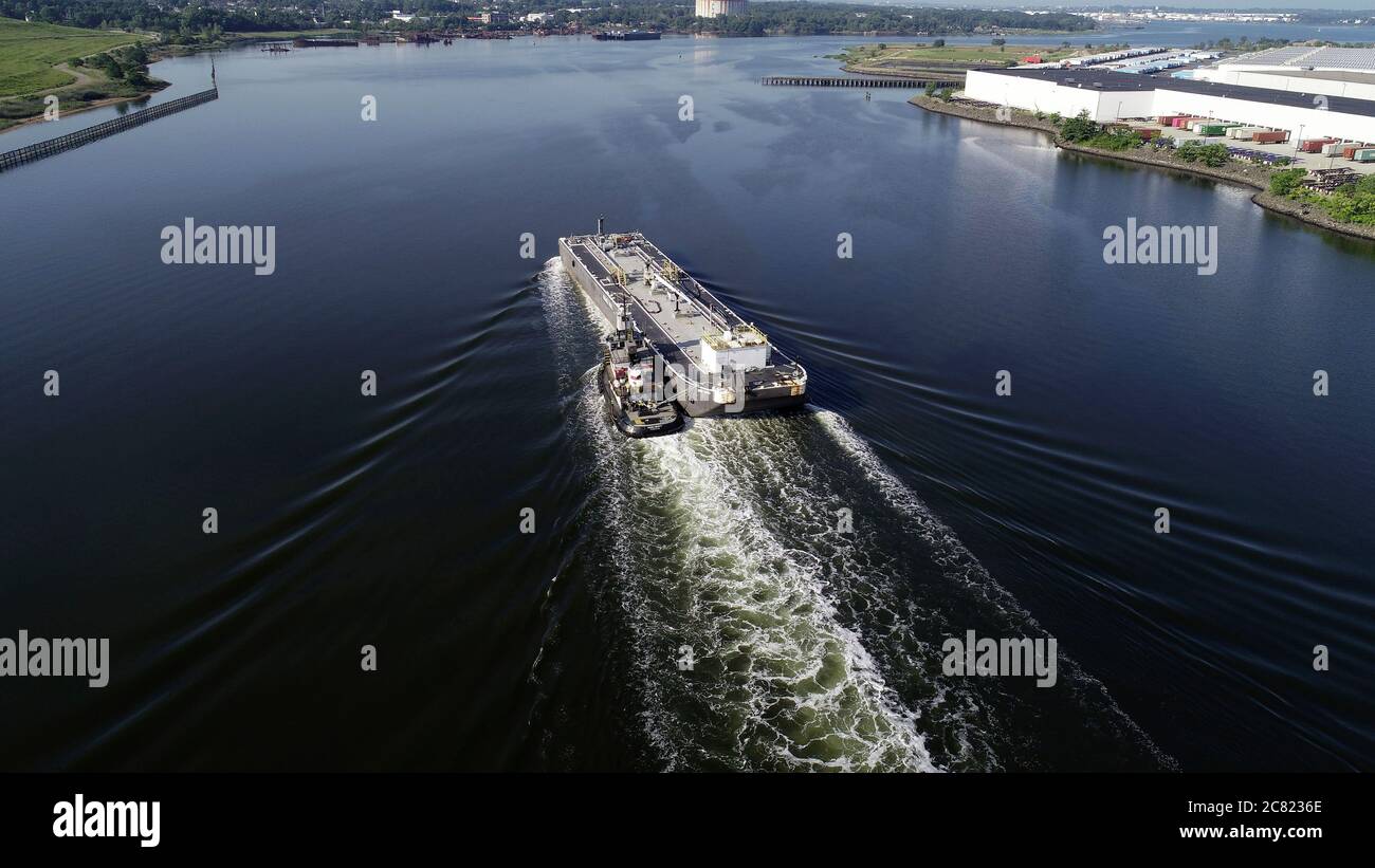 Aerial view of tugboat pushing tanker along the Arthur Kill between New ...