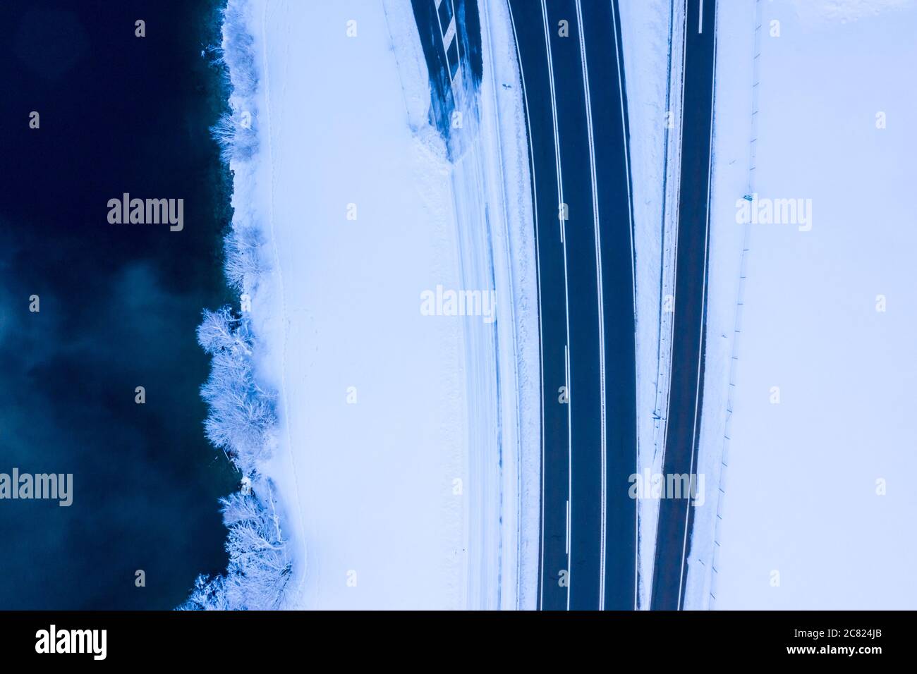 Aerial overhead shot of empty roads surrounded by snow and trees Stock ...