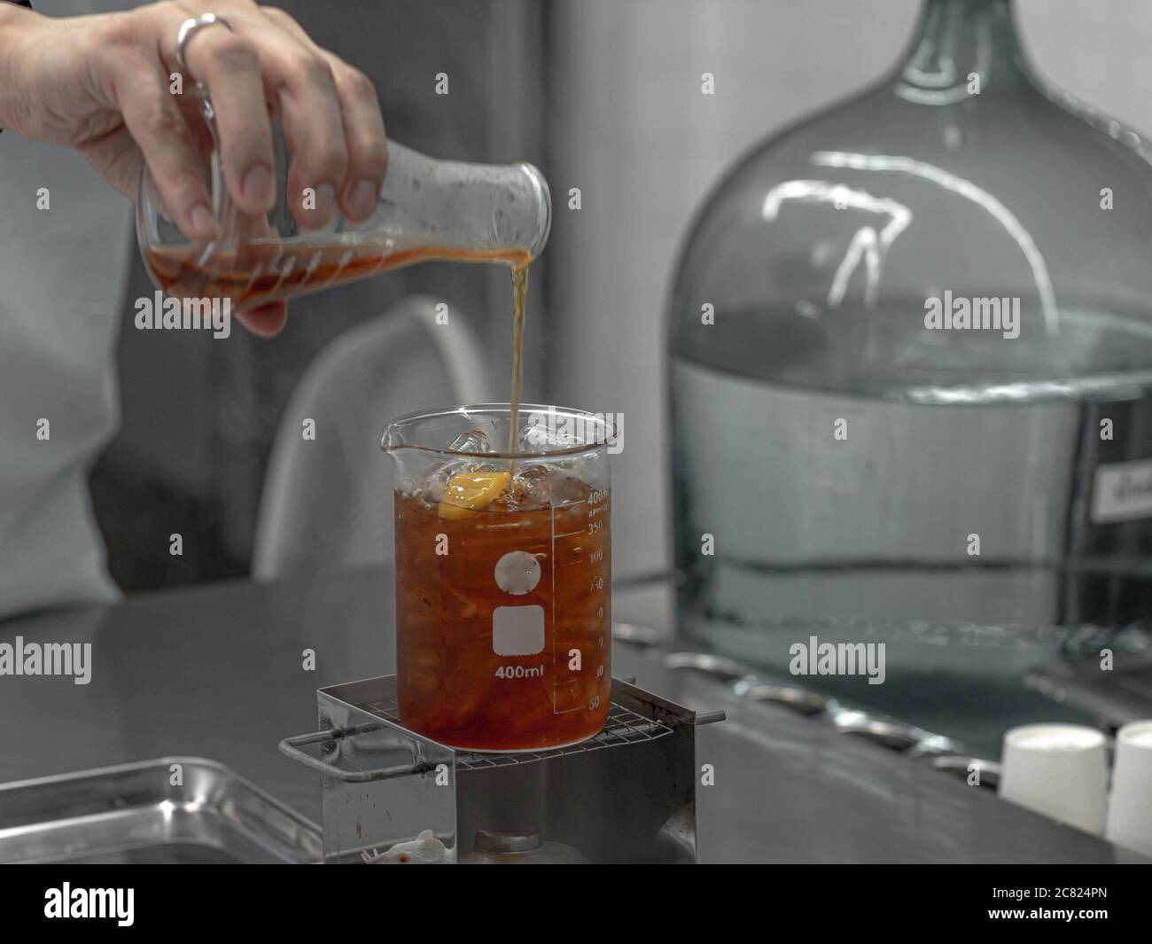 Barista hand holding Lab Borosilicate Glass Beaker Mixing tea drink ...